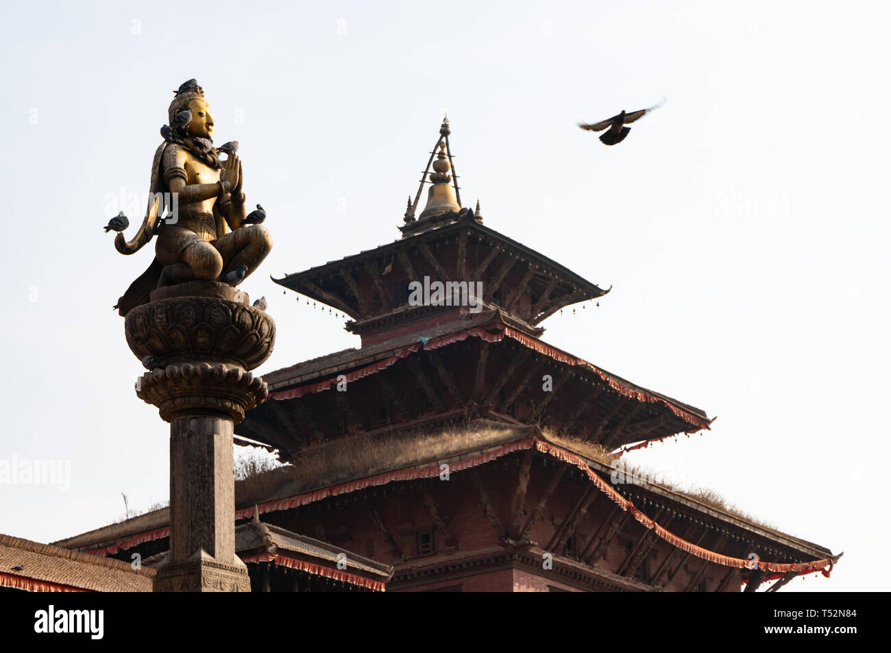 Beautiful sculpture of Garuda on a stone pillar, in the foreground of ...