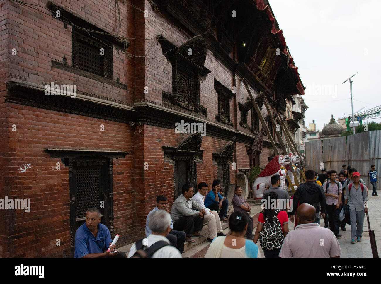 Kathmandu, Nepal - June 02, 2017: Crowd passing by and some people sit ...