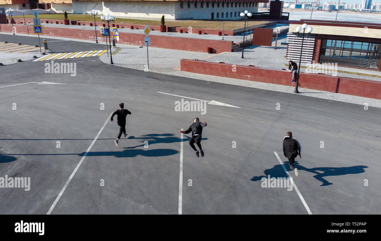 Three young men running on the road. Aerial view Stock Photo - Alamy