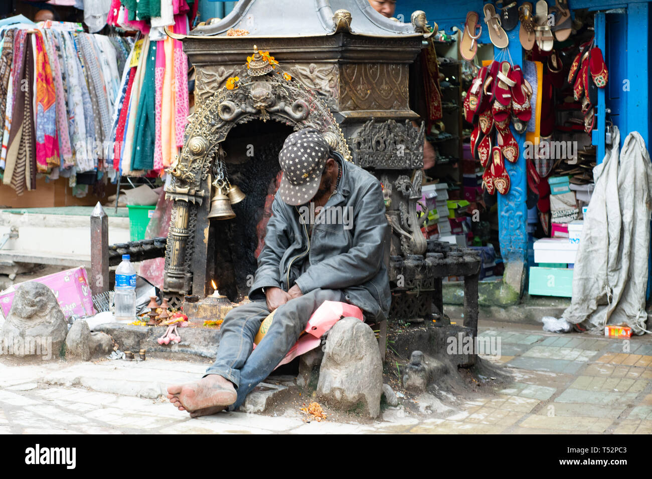 Kathmandu, Nepal - August 19, 2017: A poor man sitting near a small ...