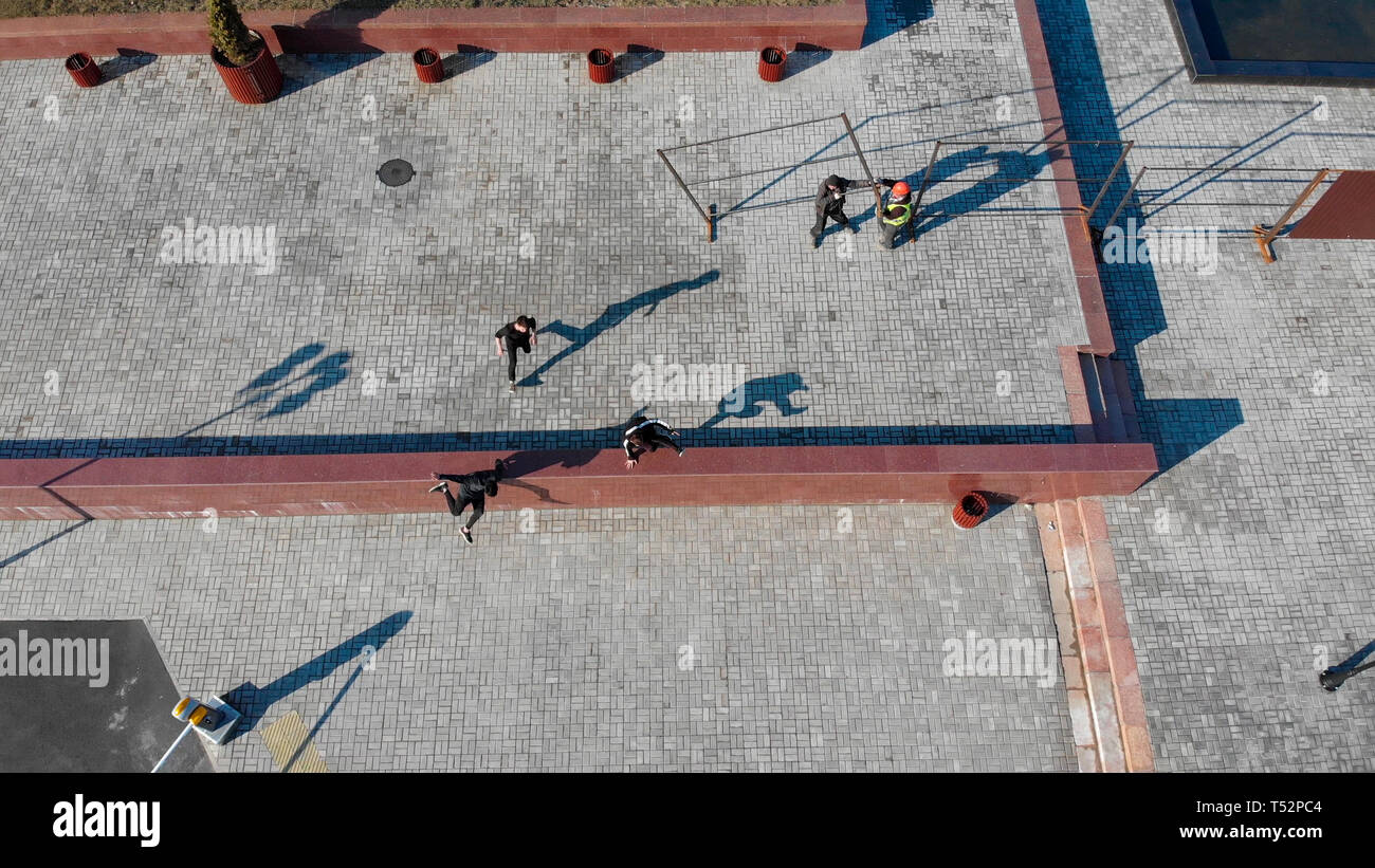 Three young men overcoming obstacles. Aerial view Stock Photo - Alamy