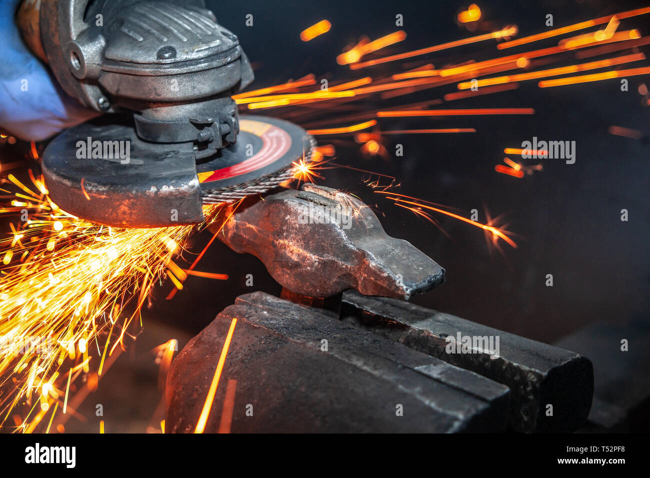 Close-up on the sides fly bright sparks from the angle grinder machine ...