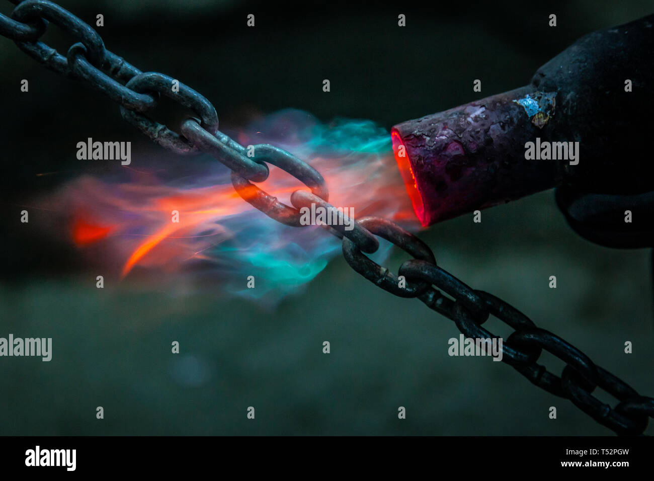 Close-up male welder welds metal using a gas burner. Worker use gas ...