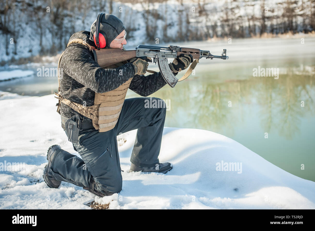 Army soldier in crouching position shooting from rifle machine gun on ...