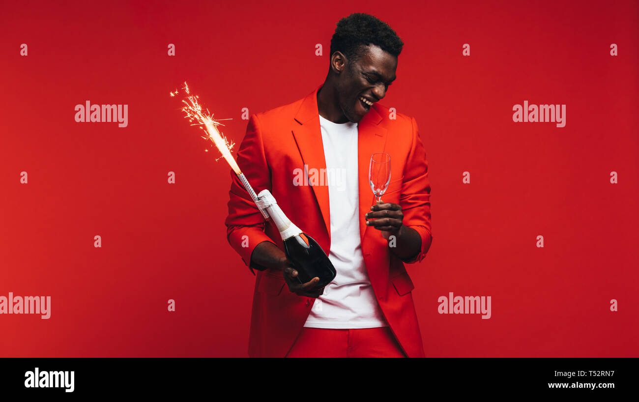 African man celebrating new years with champagne and firework. Stylish ...