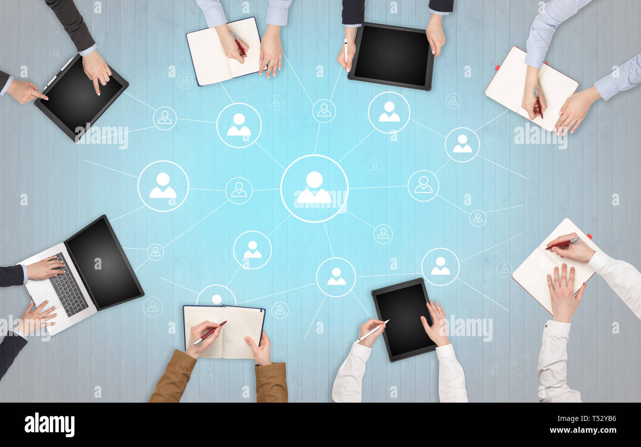 Group of people with devices in hands working in team on tablets ...