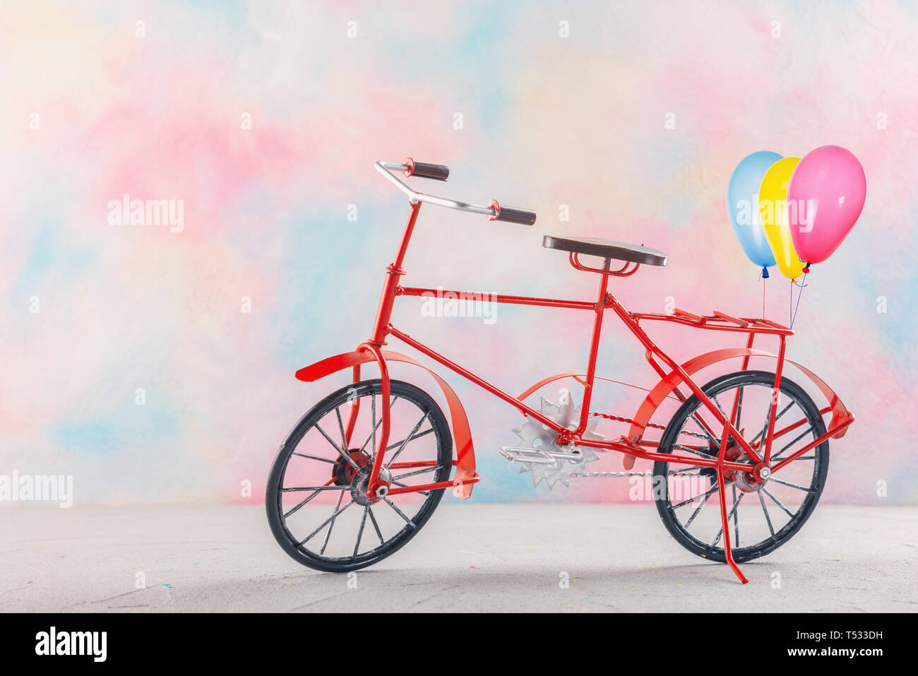 Bicycle with balloons with a bright color background Stock Photo - Alamy