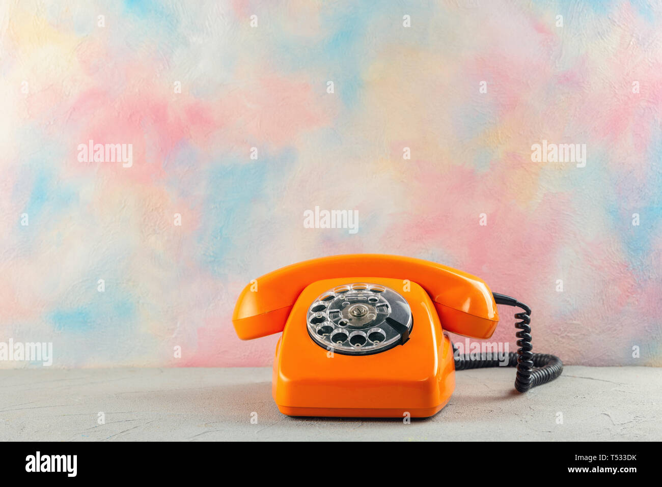 Orange vintage telephone with a bright color background Stock Photo - Alamy