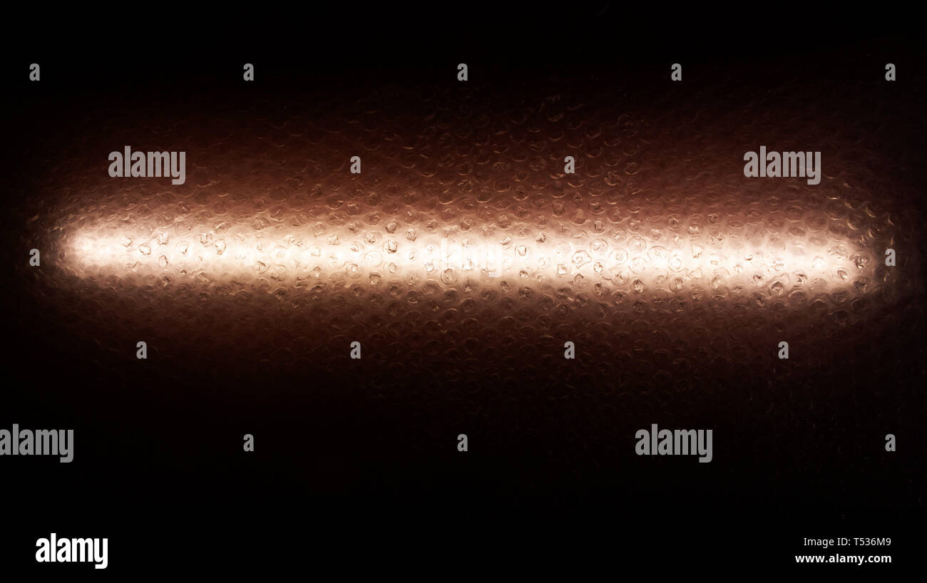 Bubble wrap with water droplets, backlit with LED light. Texture and ...