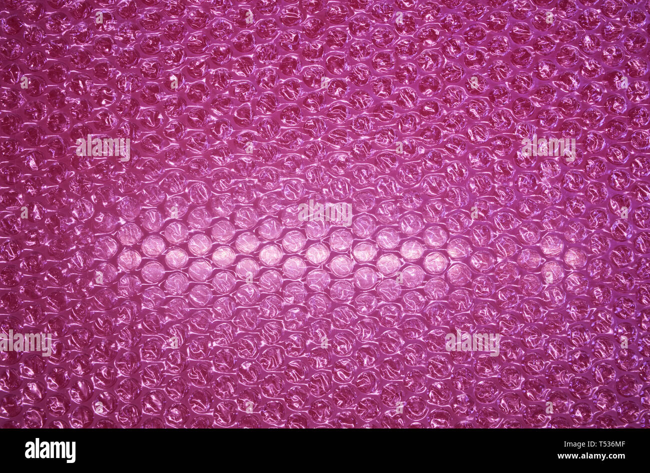 Bubble wrap is illuminated with a purple LED light. Texture and ...