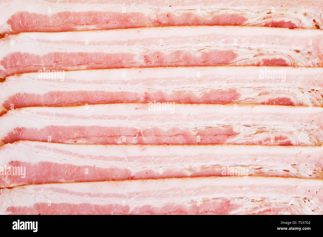 Background of sliced horizontal pieces of bacon. Edible texture. Rustic ...