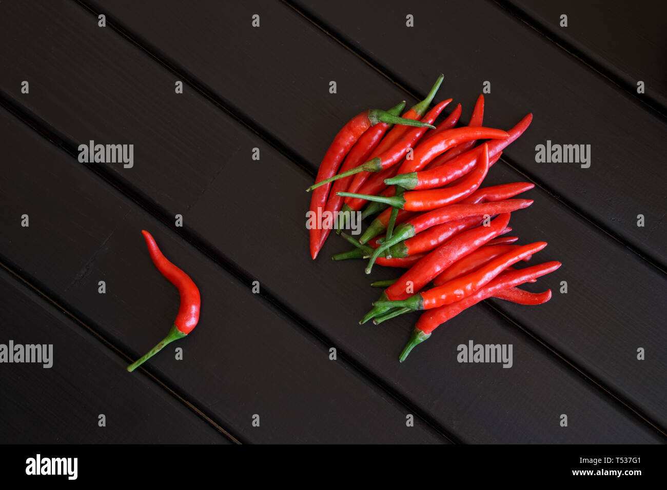 Red hot chilli pods lie on black wooden boards. Seasoning and healthy ...