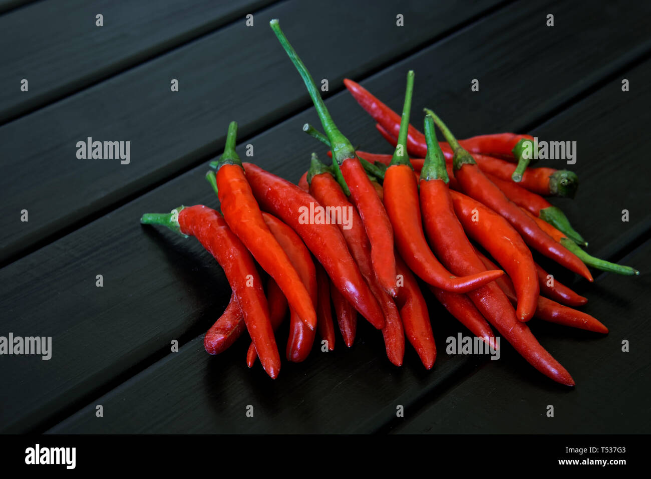 Red hot chilli pods lie on black boards. Seasoning and healthy food ...