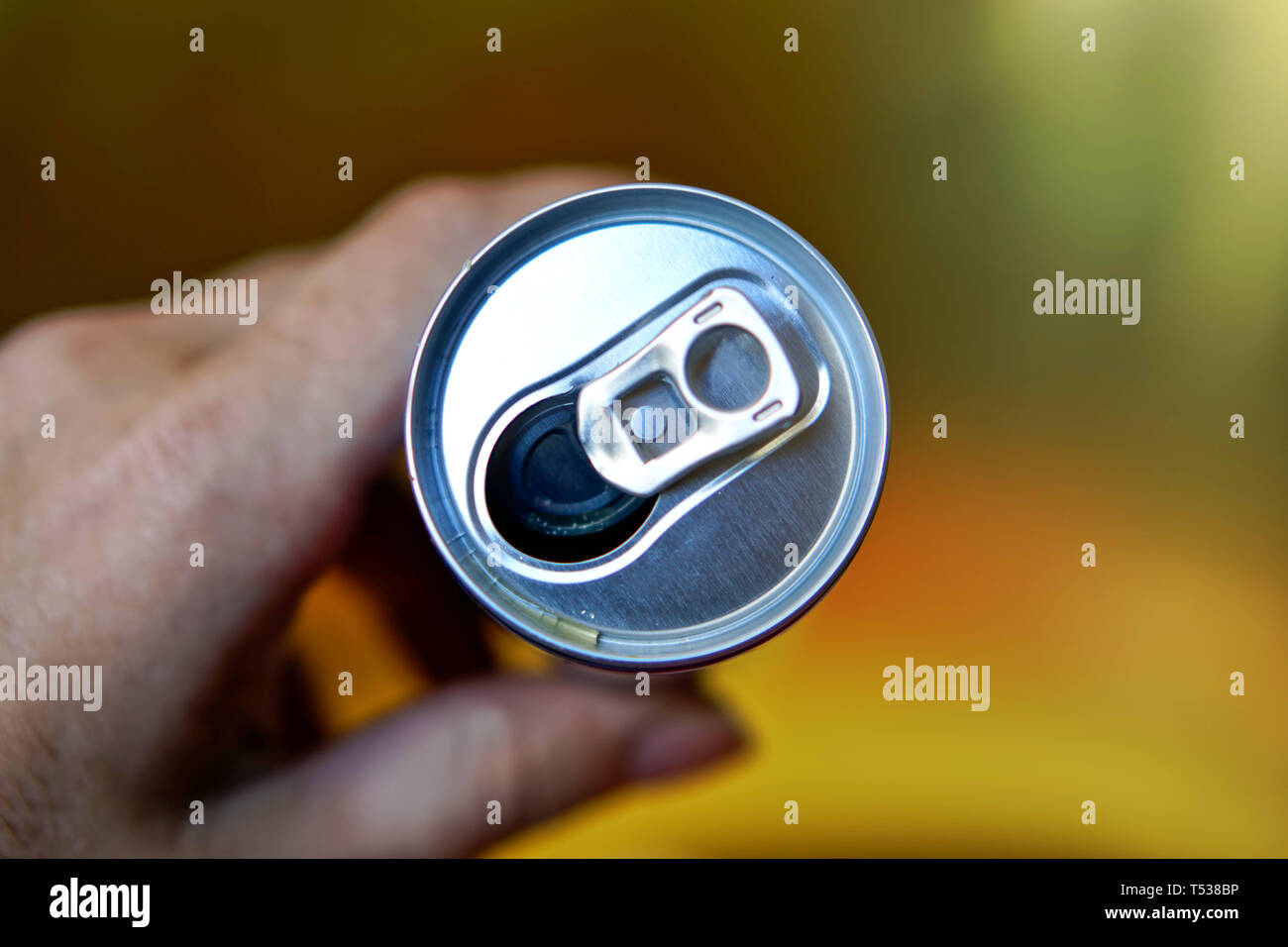 A man holds an open aluminum can of drink. View from above. Shallow ...