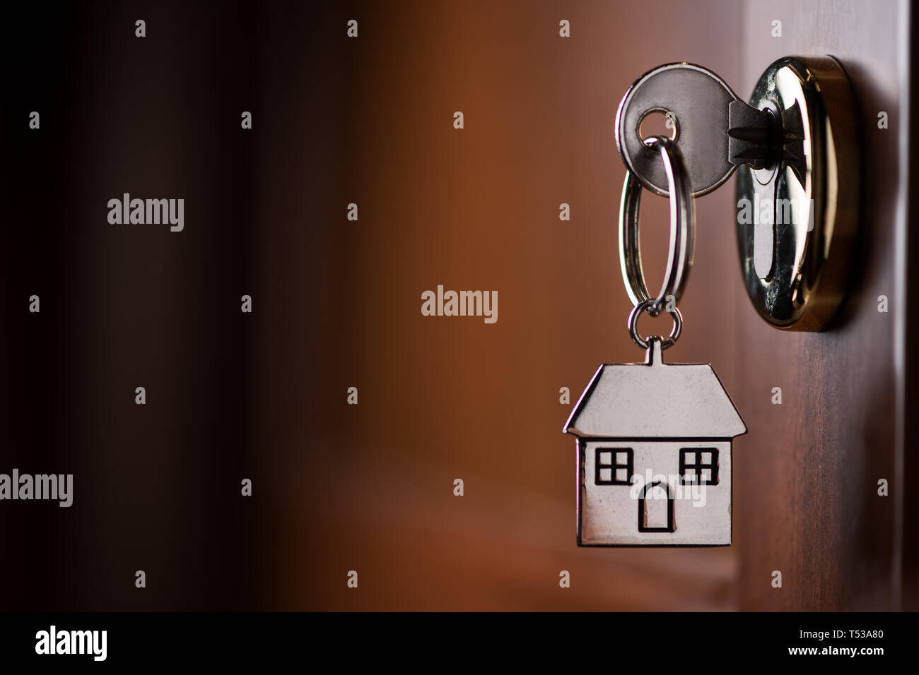 House key on a house shaped silver keyring in the lock of a door Stock ...