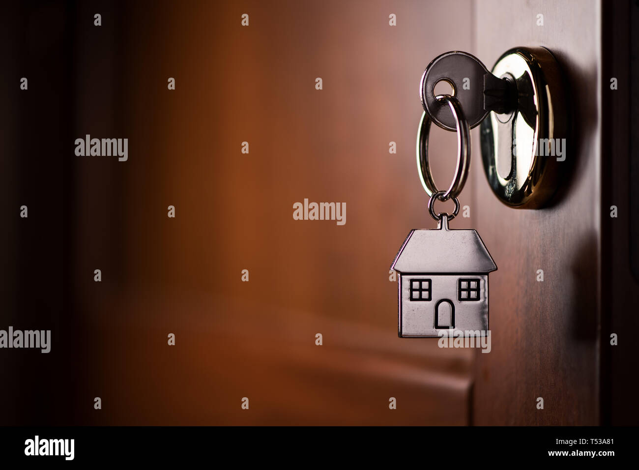House key on a house shaped silver keyring in the lock of a door Stock ...