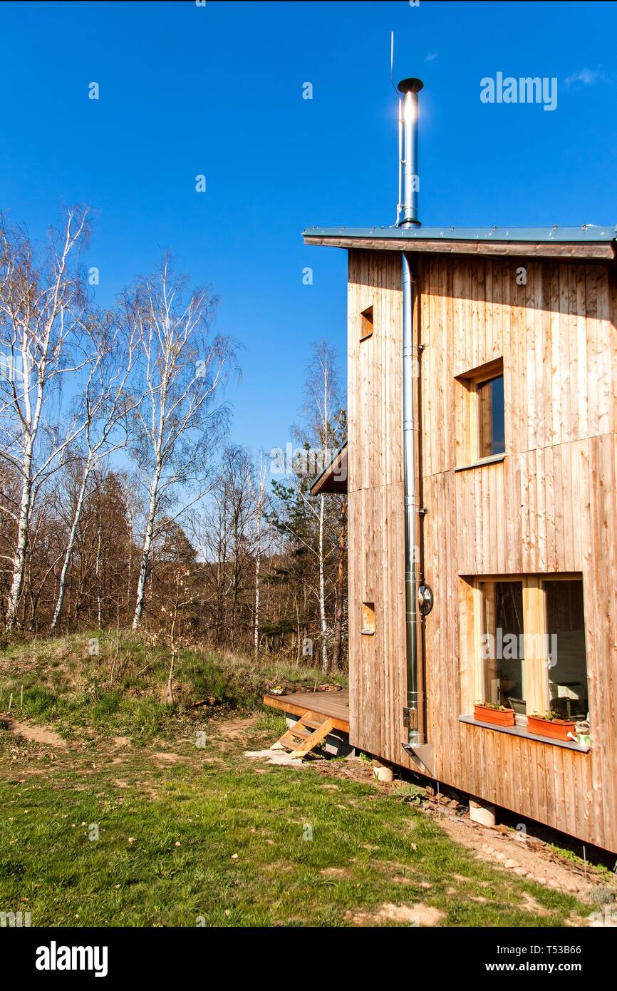 Stainless steel chimney on ecological wooden building. Building a ...