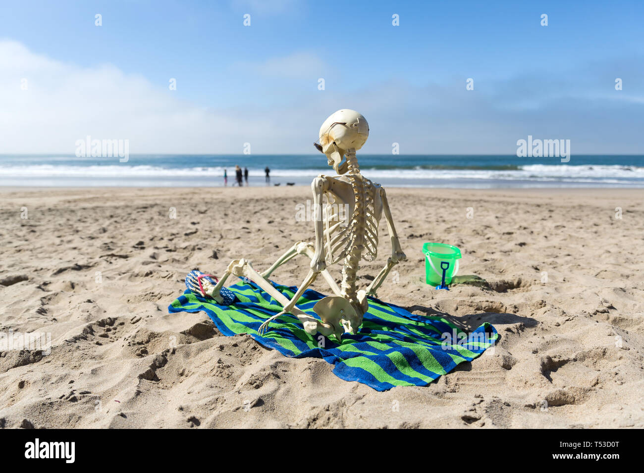 Skeleton sits on a beach towel relaxing in the sand Stock Photo - Alamy