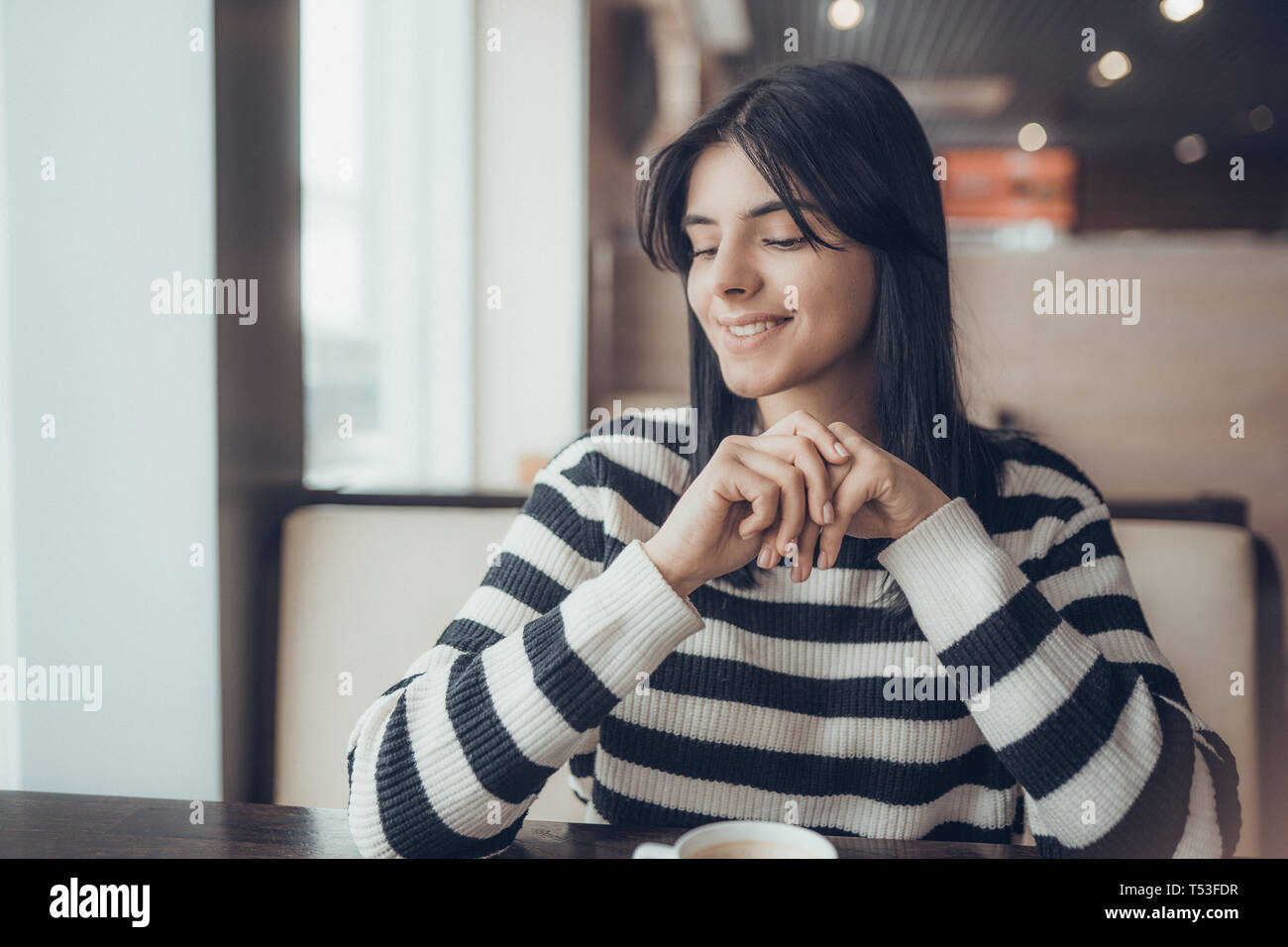 Beautiful caucasian girl in casual clothes smiling while sitting in ...