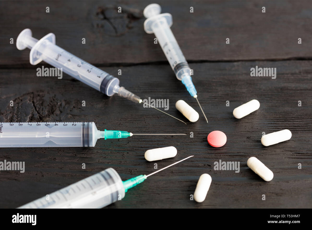 Medical syringes of various capacities, capsules, tablets lie on an old ...