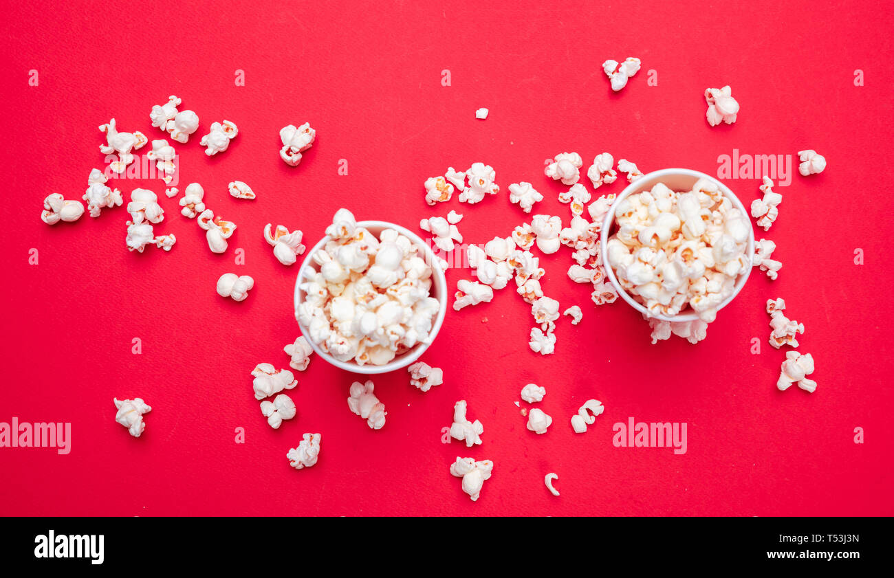 Fresh salty pop corn in two red carton containers, red color background ...