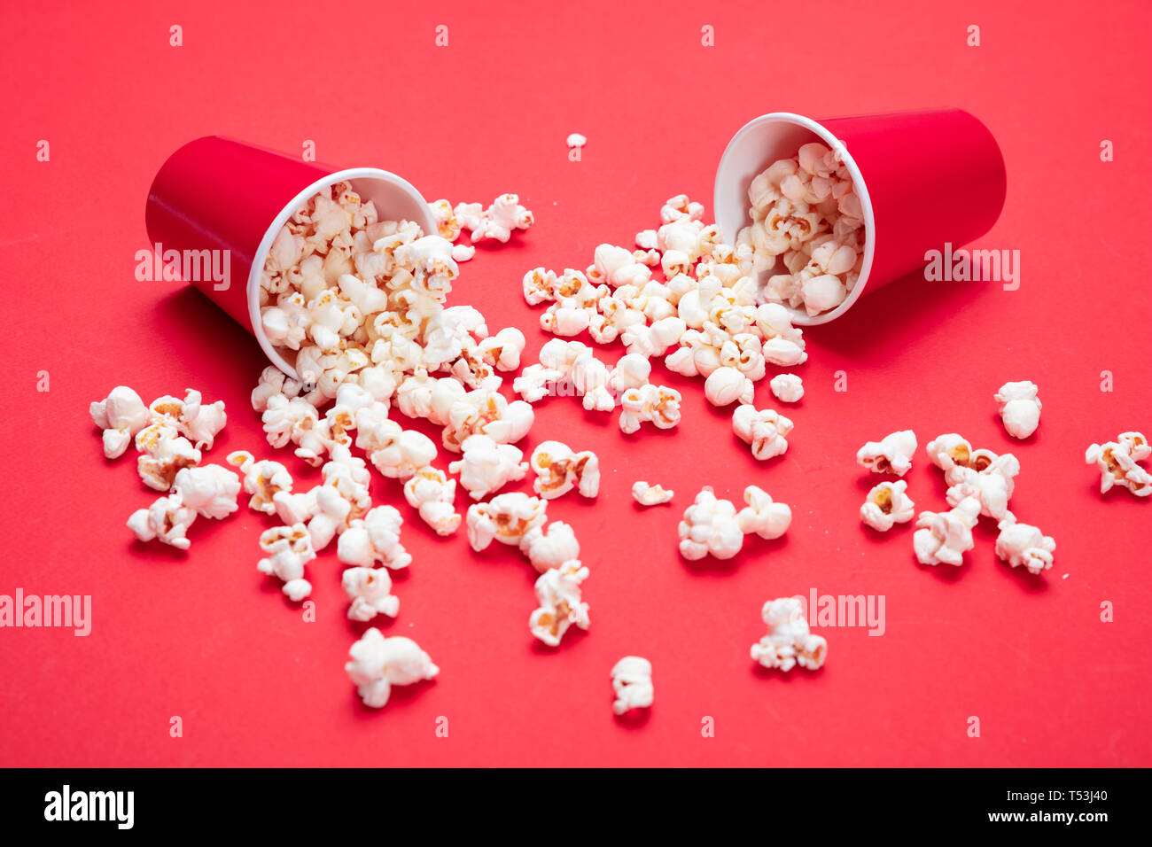 Fresh salty pop corn spilled out of two carton containers, red color ...
