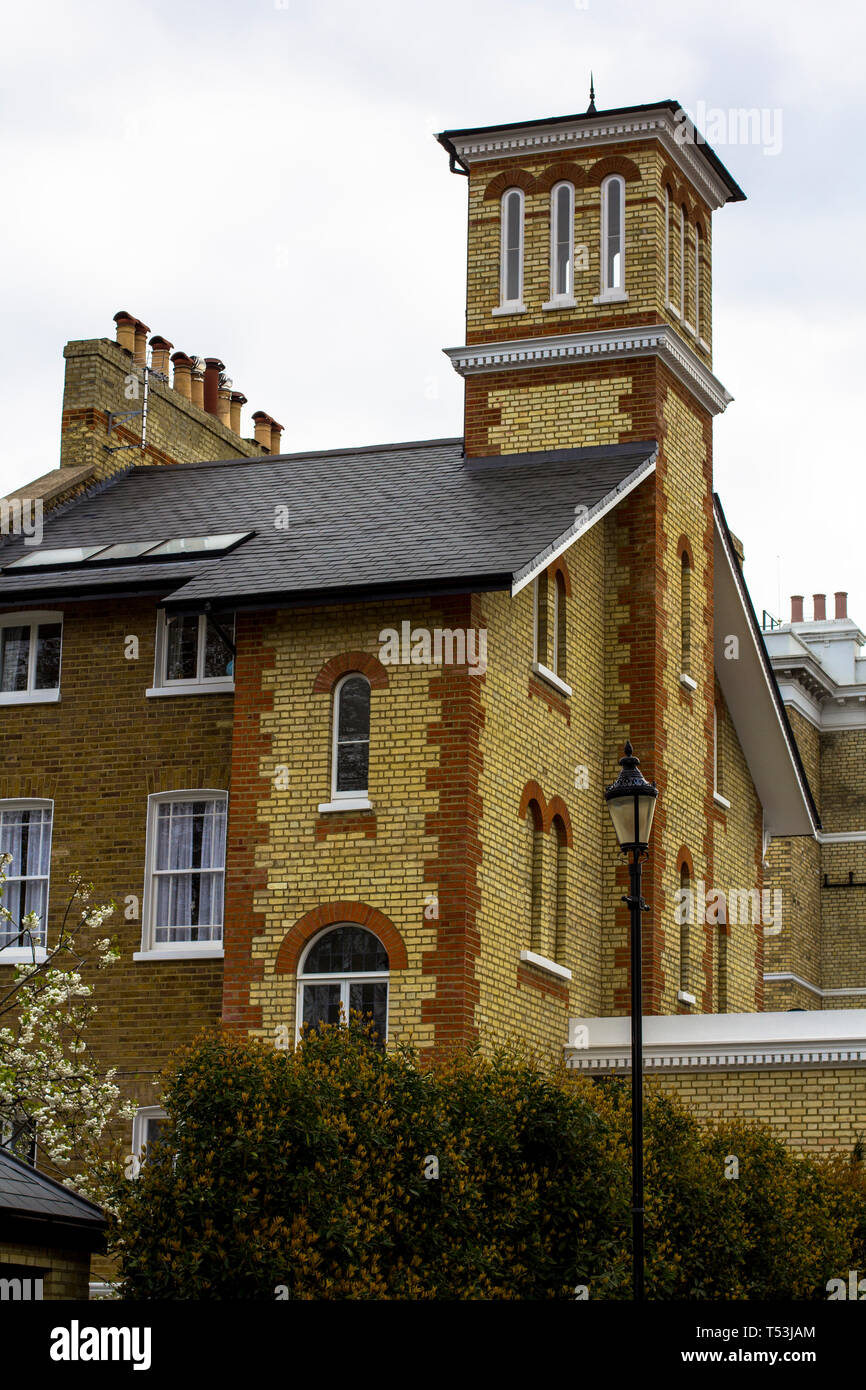 Brick house with white windows and a tower in a quiet area of central ...
