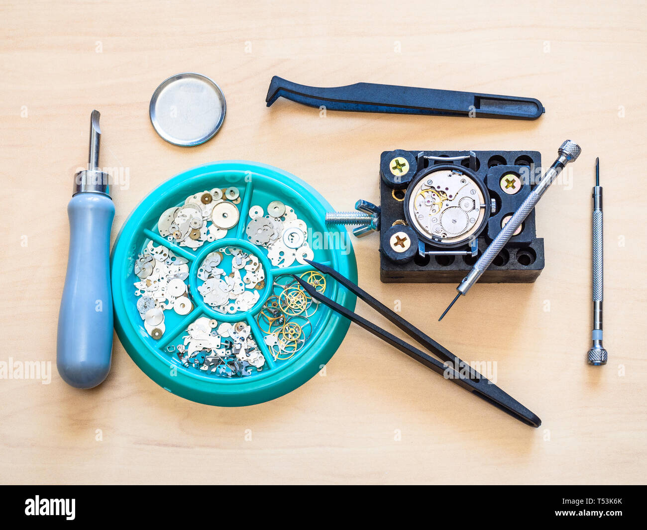 top view of watch repairing tools and spare parts on table in workshop ...