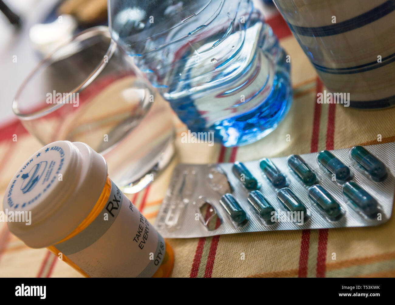 Medication during breakfast, capsules next to a glass of water ...