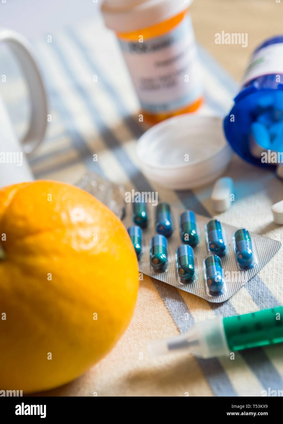 Medication during breakfast, capsules next to a orange, conceptual ...