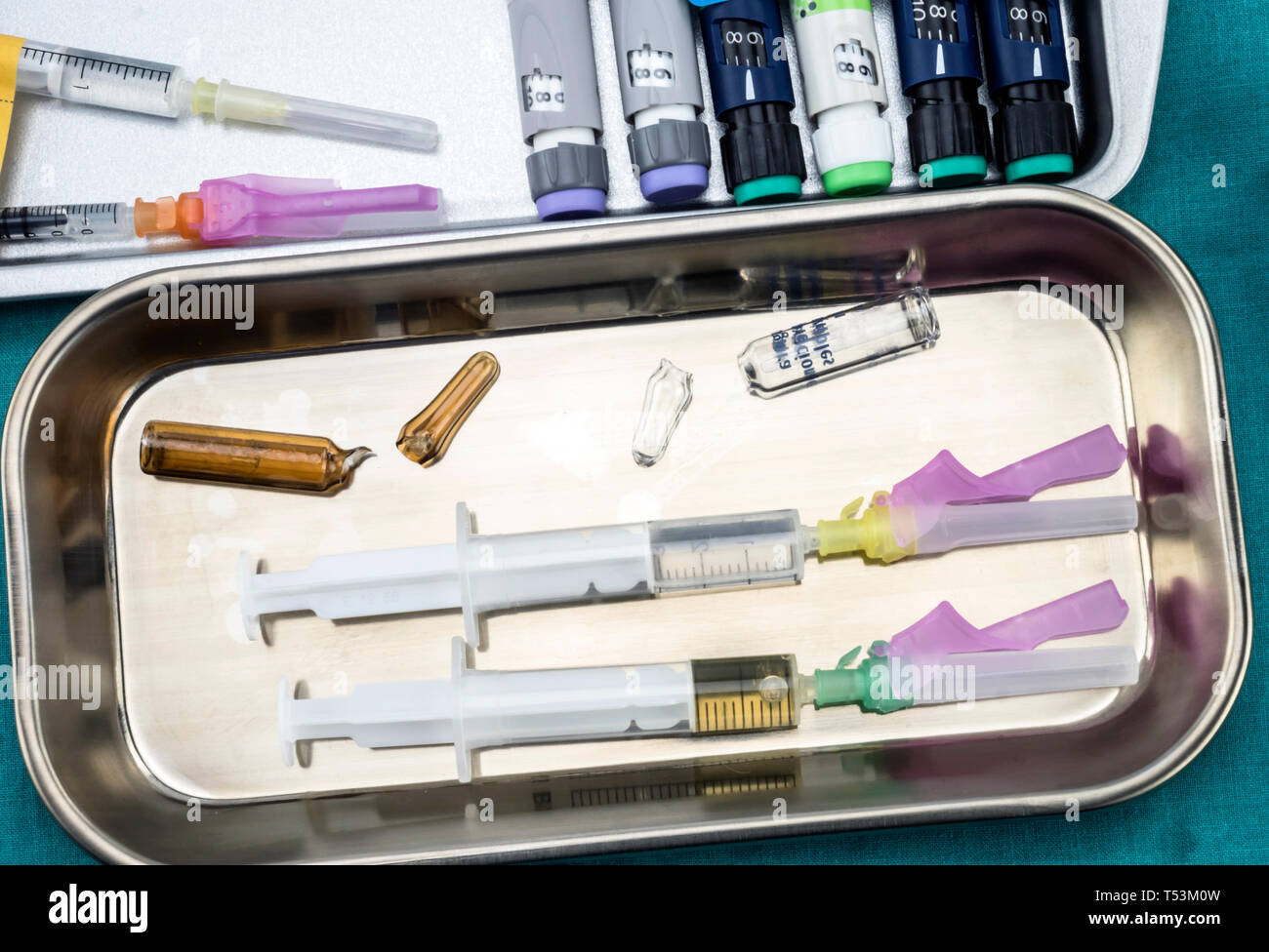 Syringes loaded with medication next to medicine vials prepared in ...