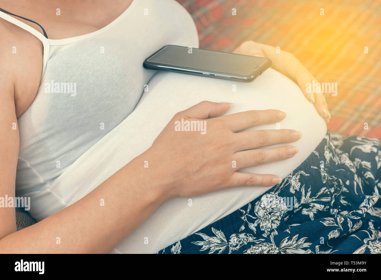 Pregnant woman using cell phone on her belly. Waiting for that ...
