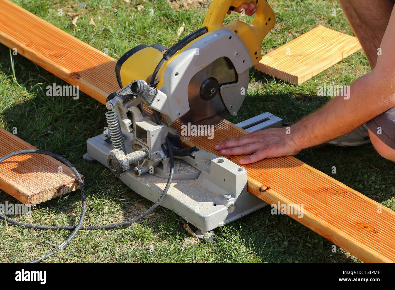 A worker saw wood with a chop saw Stock Photo - Alamy