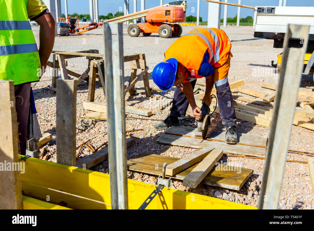 Worker is using abrasive grinding machine to set up armature to right ...