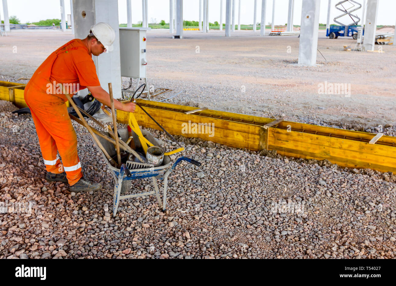 Construction worker is picking up used equipment for earthworks in ...