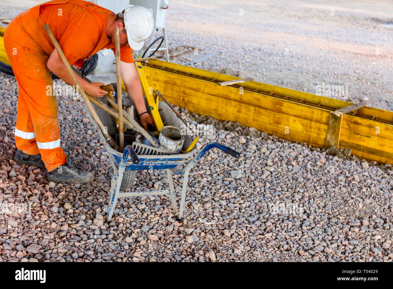 Construction worker is picking up used equipment for earthworks in ...