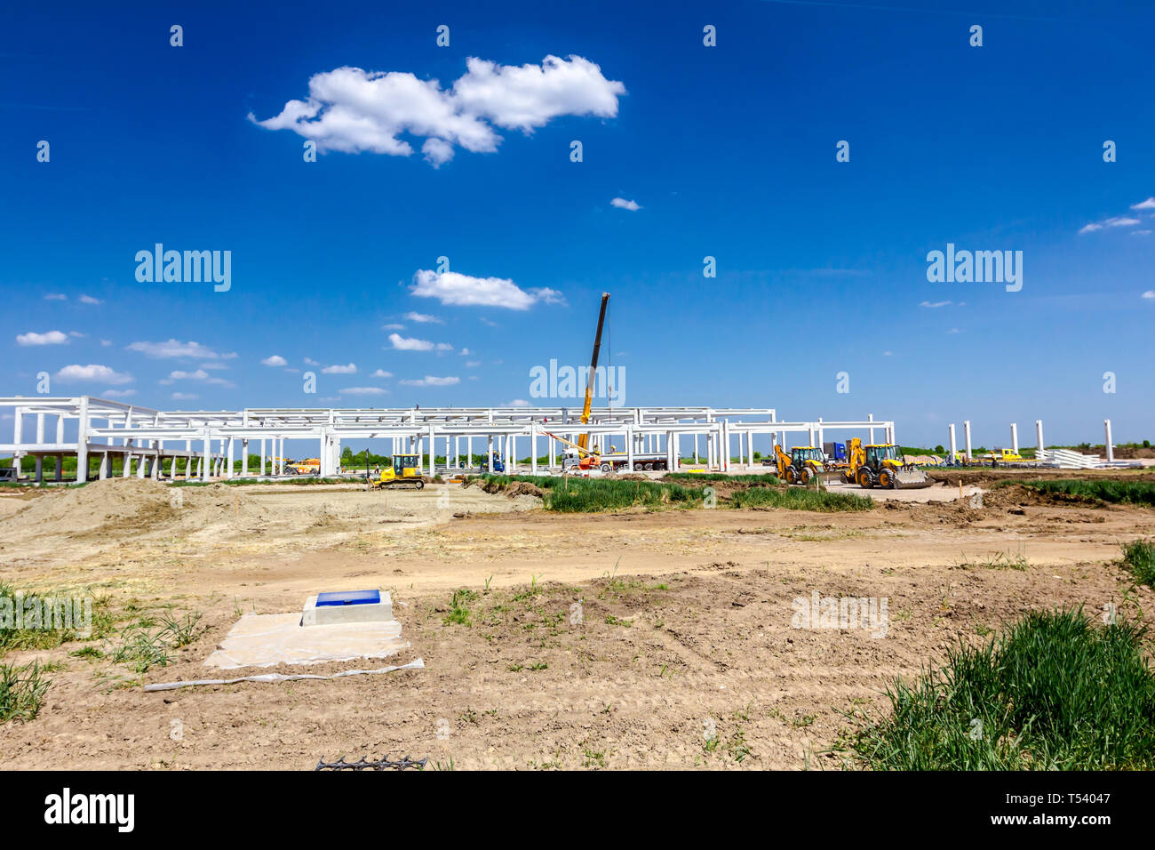 Assembly a huge concrete skeleton of industrial building with machinery ...