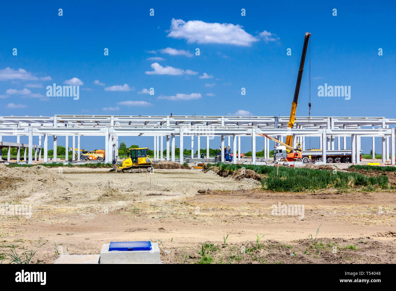 Assembly a huge concrete skeleton of industrial building with machinery ...