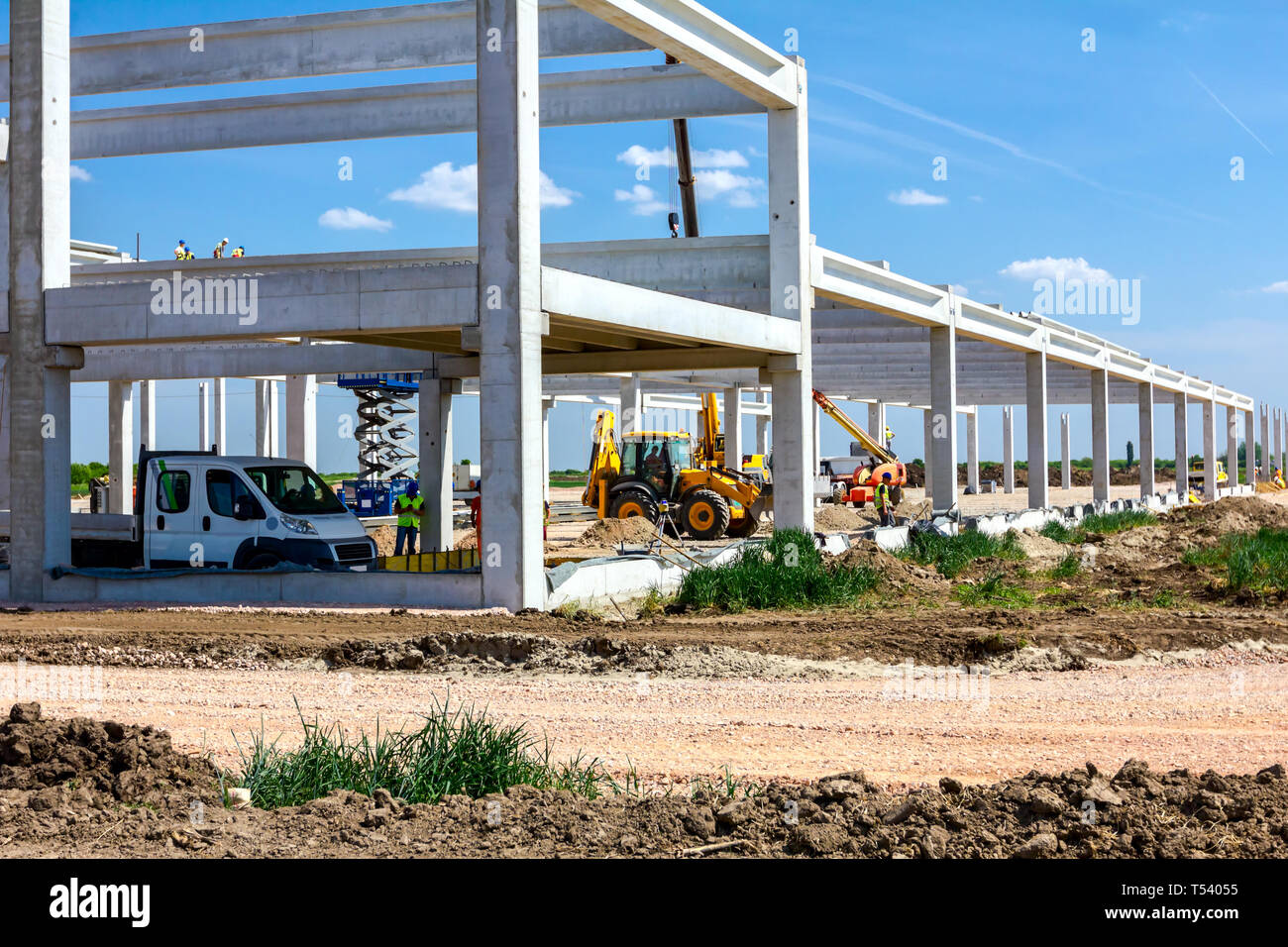 Assembly a huge concrete skeleton of industrial building with machinery ...