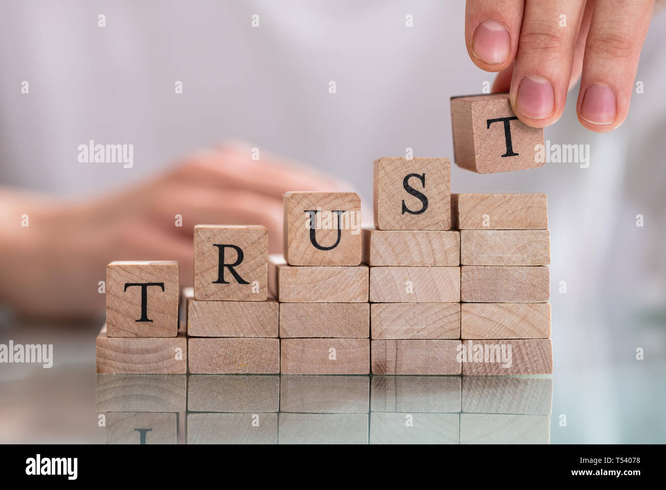Woman's Hand Placing Last Alphabet Of Word Trust Over Wooden Block ...
