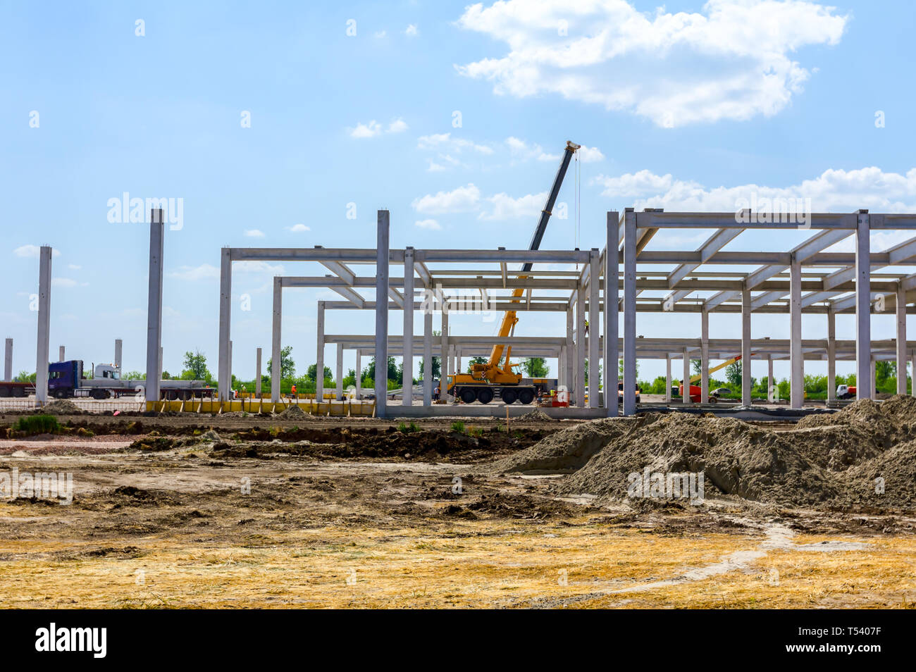 Assembly a huge concrete skeleton of industrial building with machinery ...