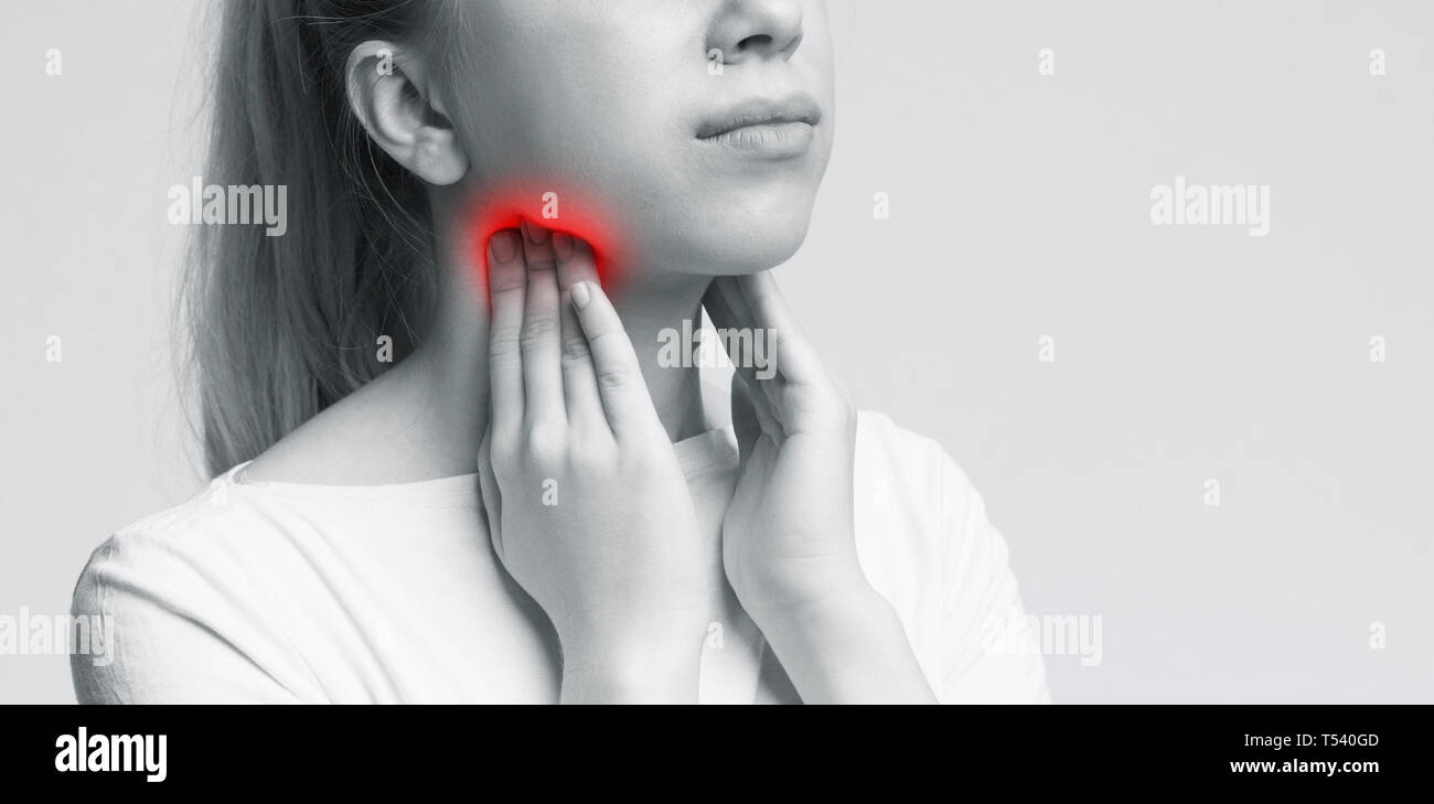 Young woman suffering from tonsillitis, pulping her neck, monochrome ...