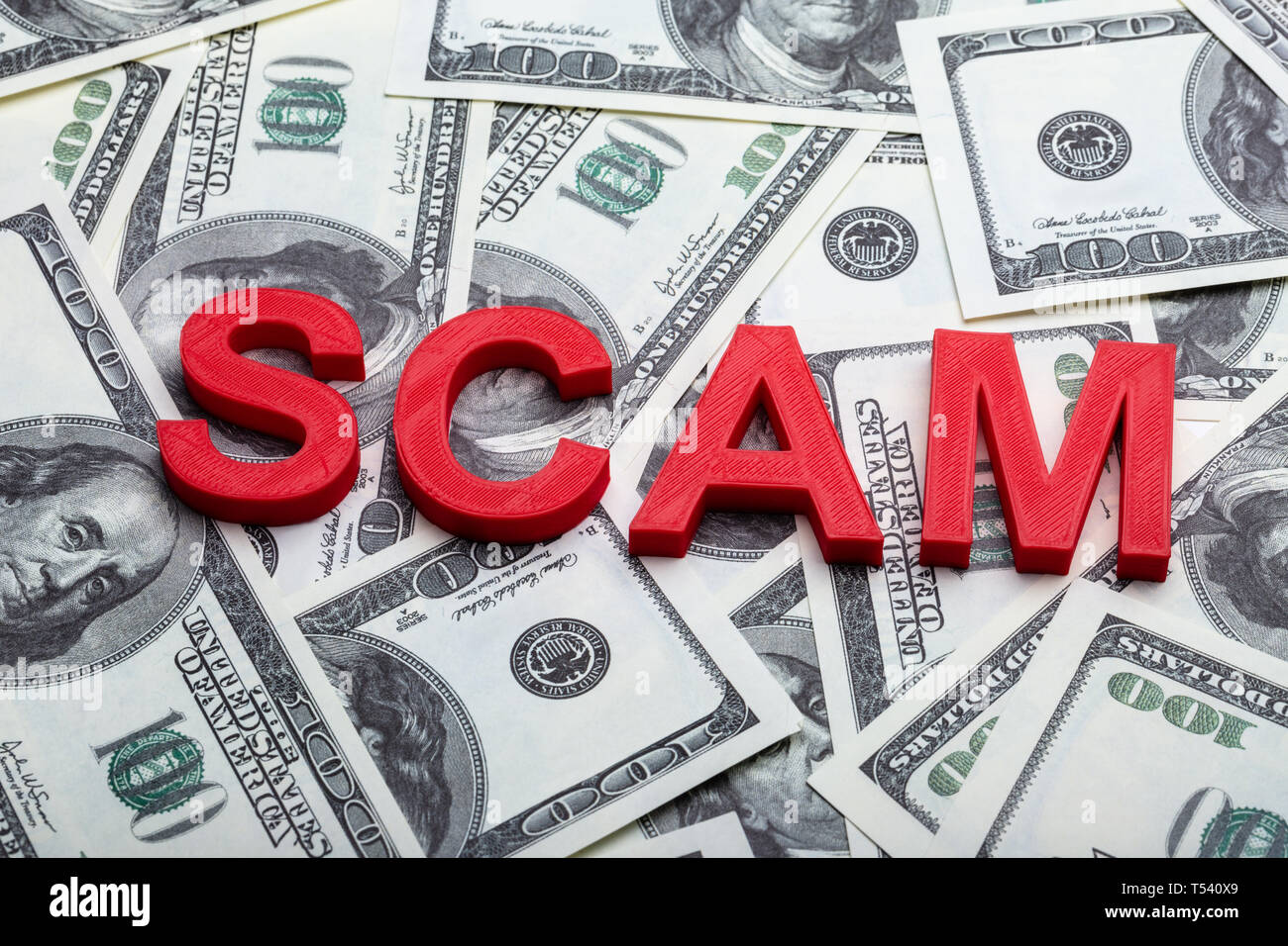 An Elevated View Of Word Scam On Hundred Dollar Bills Stock Photo - Alamy