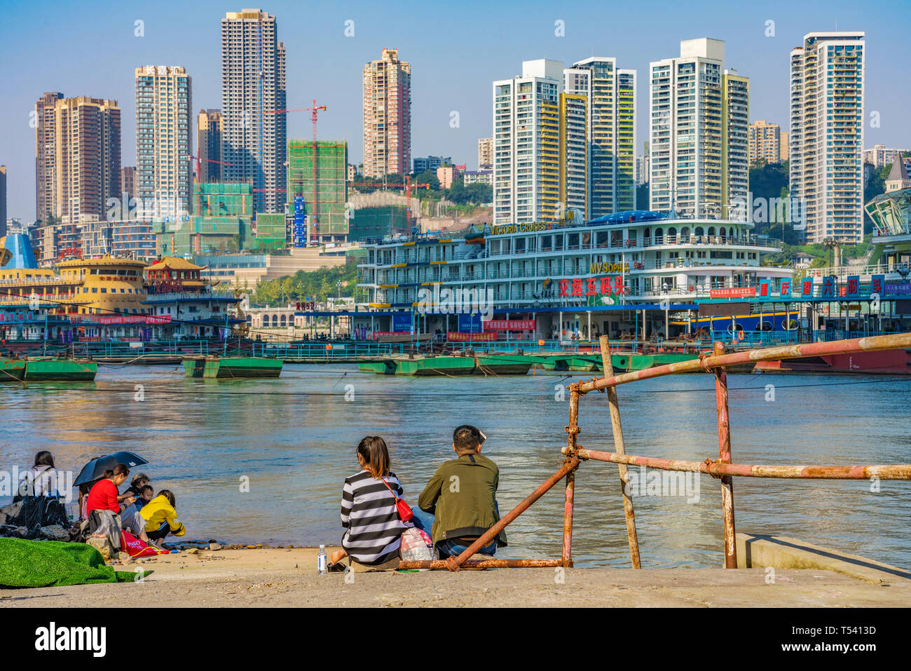 CHONGQING, CHINA - NOVEMBER 03: Riverside are with people sitting and ...
