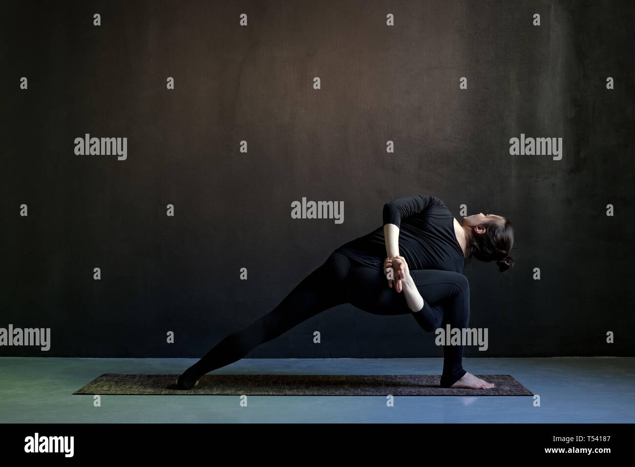 European woman doing Extended Side Angle posture Stock Photo - Alamy