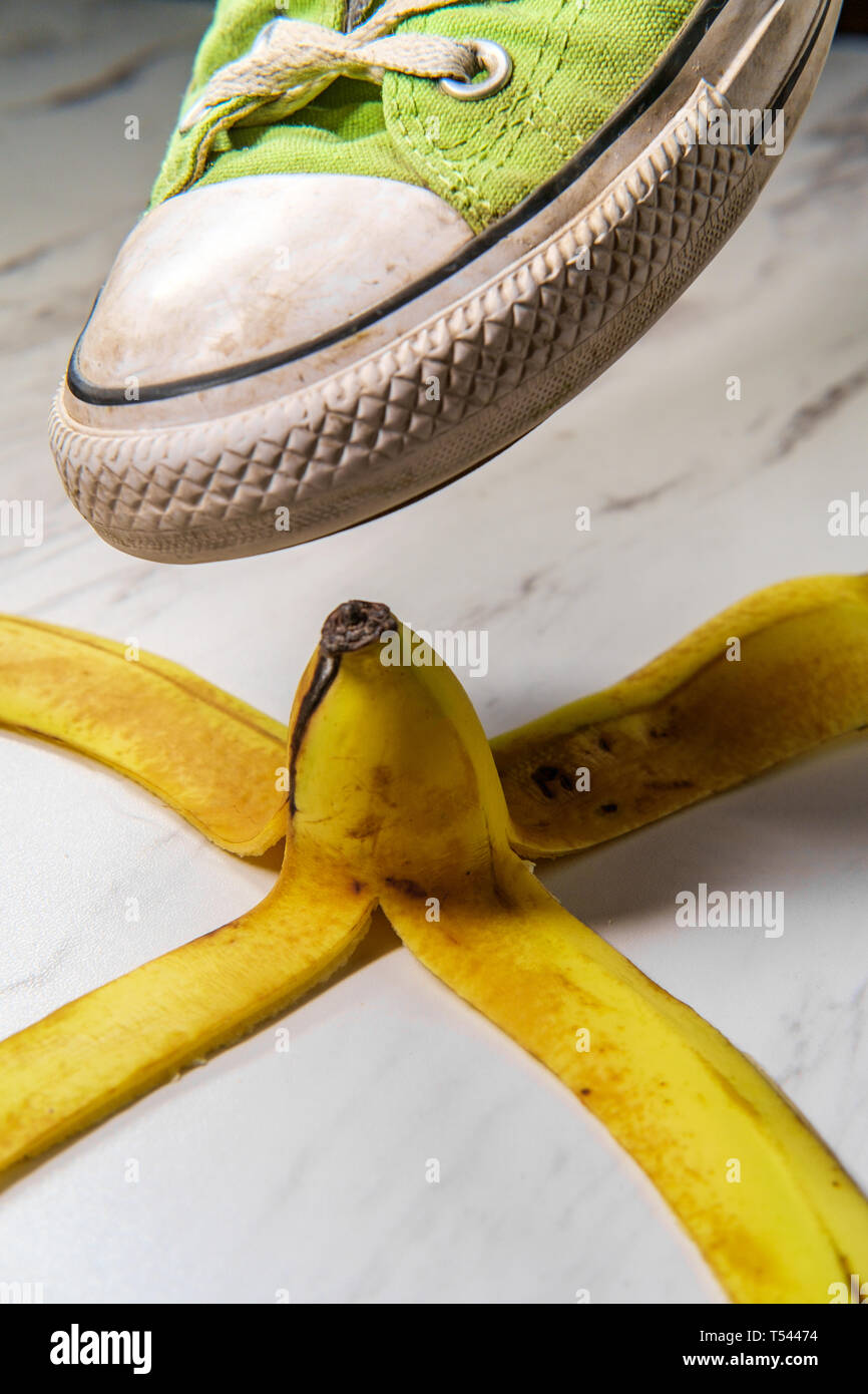 Classic slippery comedy banana peel with sneaker about to step on it ...