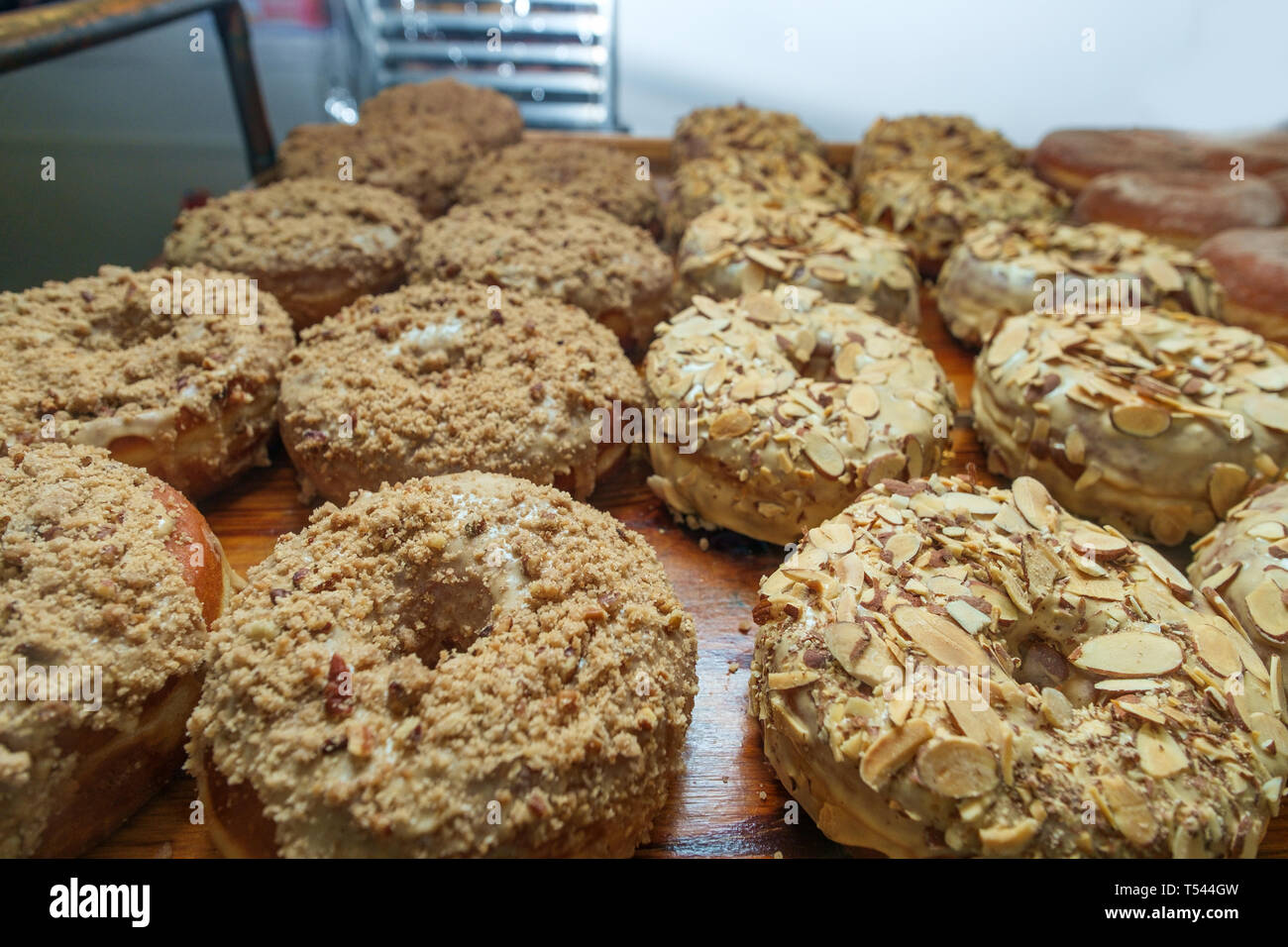Rows of fresh almond donuts with holes on display Stock Photo - Alamy