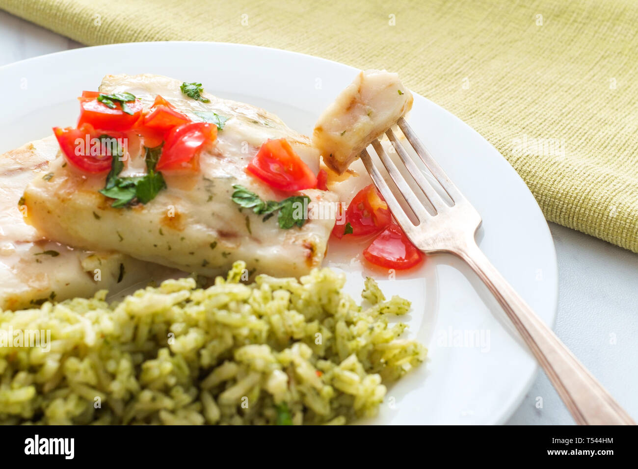 Grilled Alaskan Pollock fish fillets with lemon butter and green rice ...