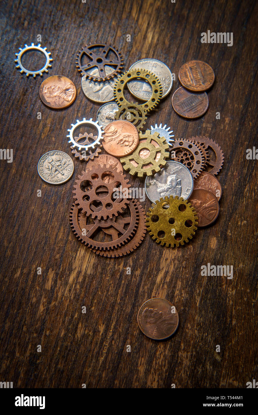 Pile of gears cogs and coins mixed together as business finance concept ...