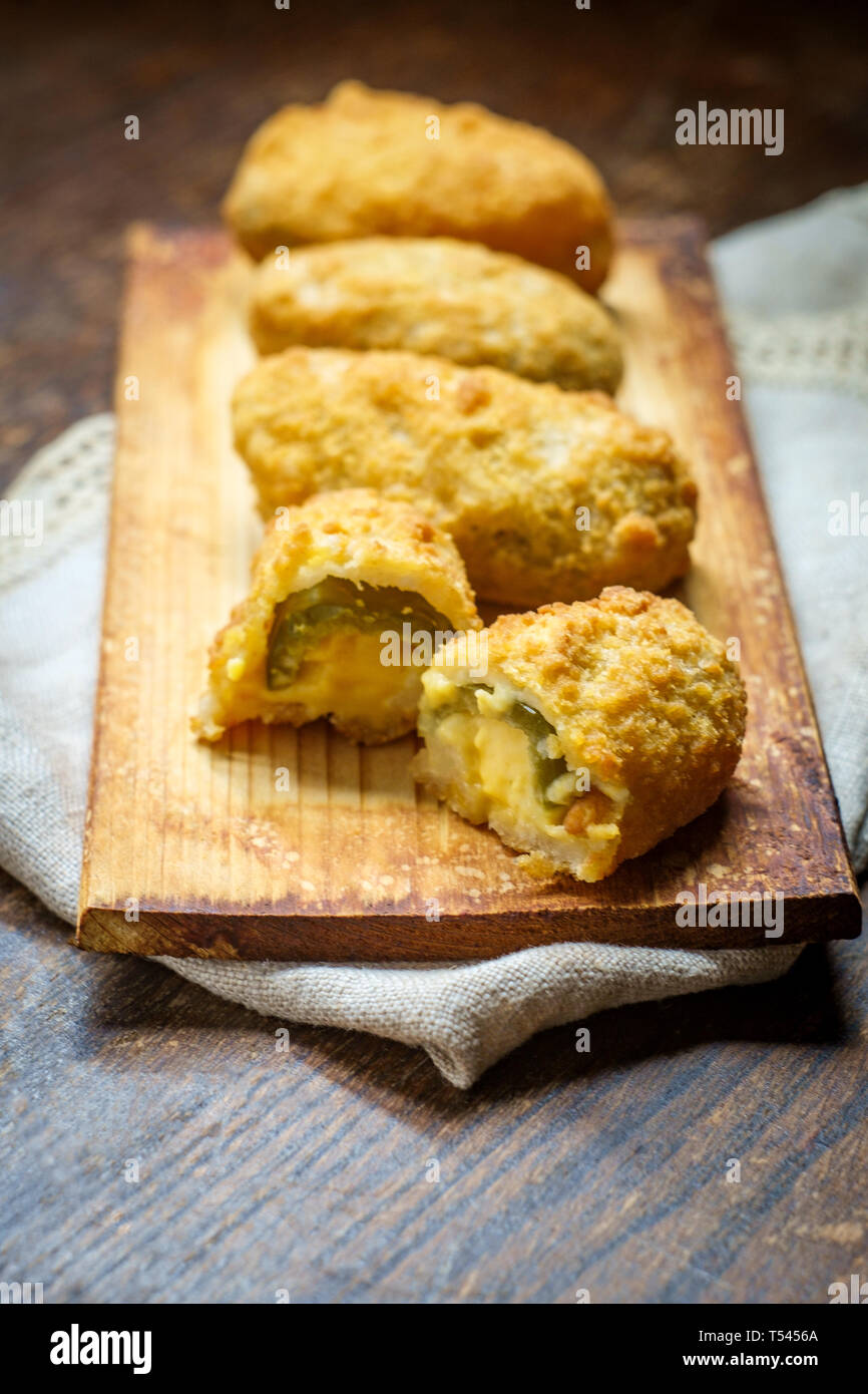 Crispy fried cheddar cheese jalapeno popper bites served on wooden ...